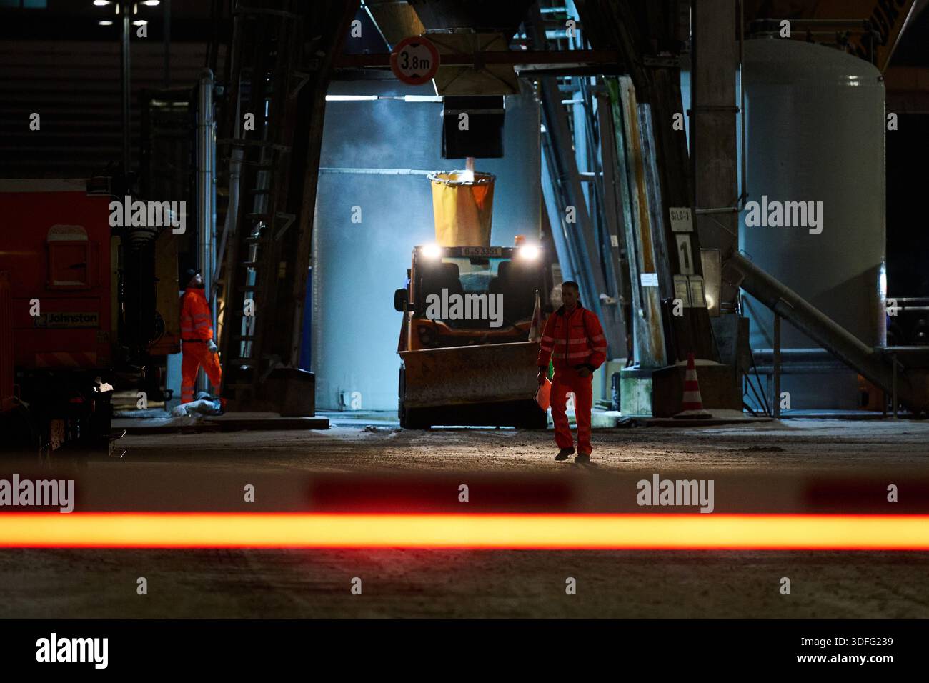 12 January 2026, Berlin: A BSR clearing and gritting vehicle loads grit ...