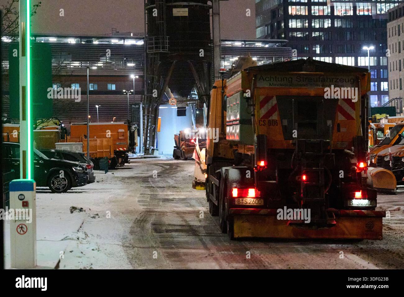 12 January 2026, Berlin: BSR clearing and gritting vehicles load grit ...