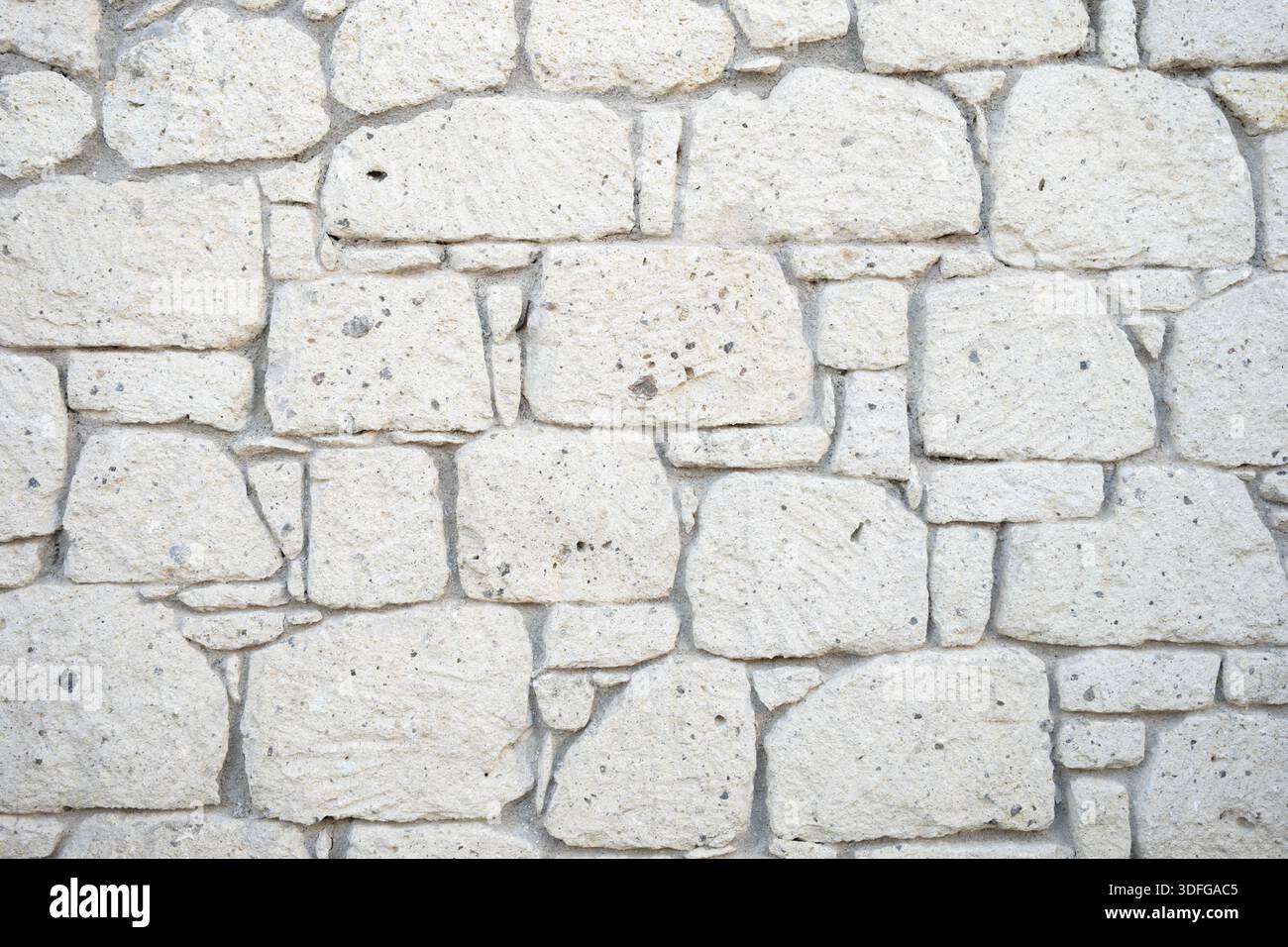 Alacati stone wall with natural limestone blocks forming irregular ...