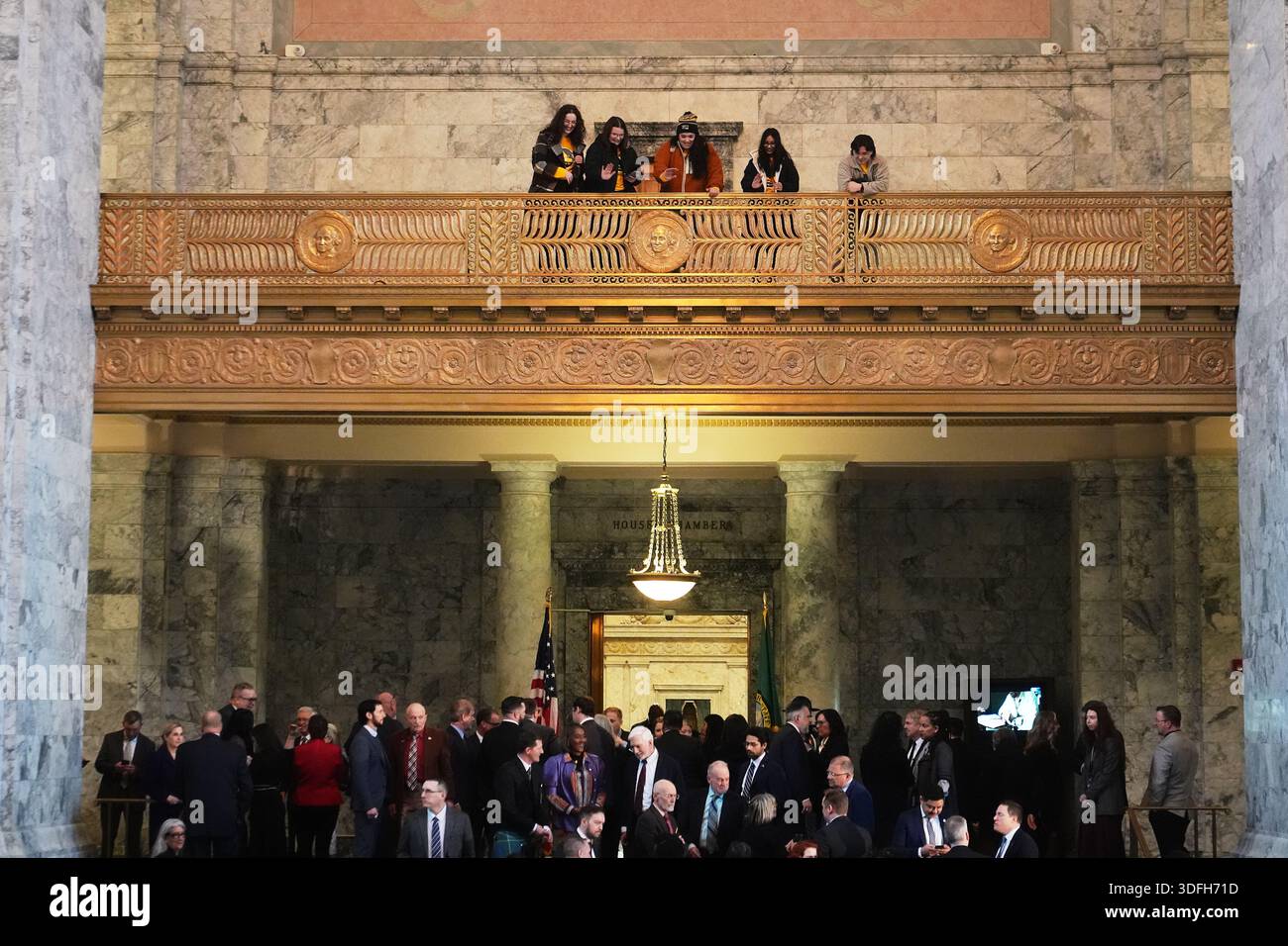 People wave from an upper level as state representatives gather outside ...
