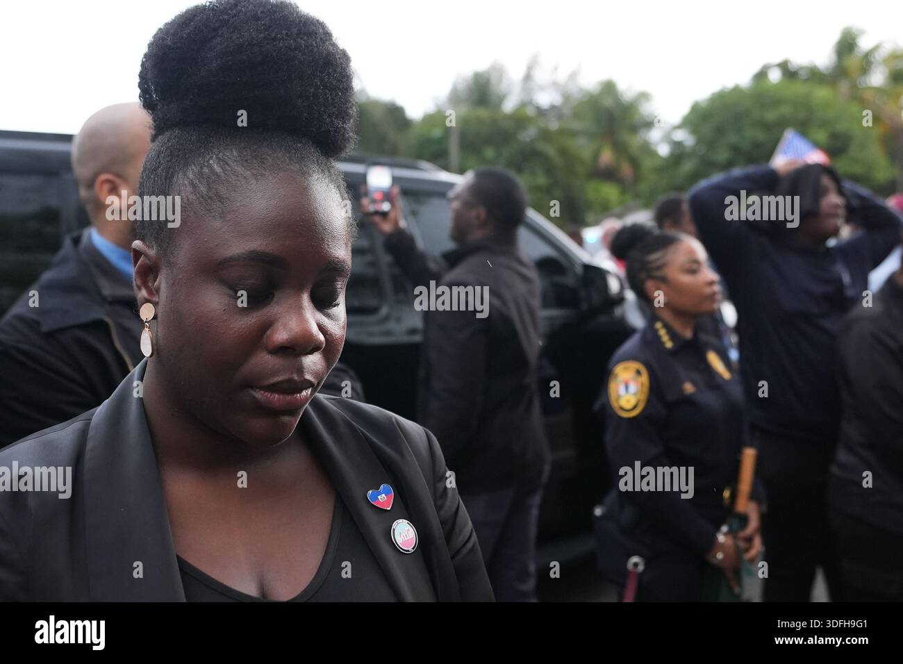 Deborah Saint-Vil stands for a moment of silence during a vigil to mark ...