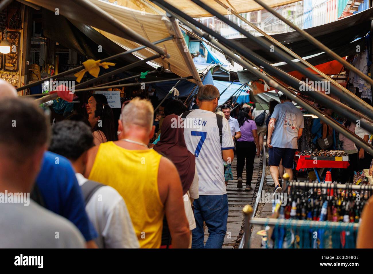 Samut Songkhram, June 14, 2025. Tourists walk along the railway track ...