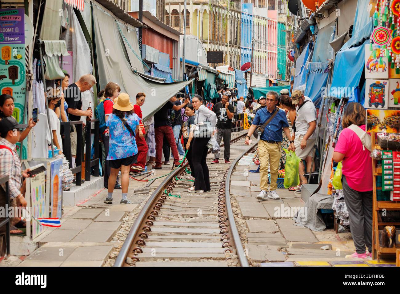 Samut Songkhram, June 14, 2025. Tourists walk along the railway track ...