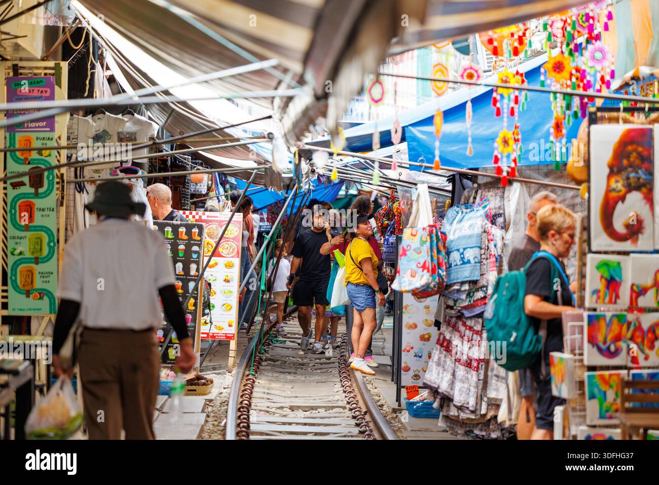 Samut Songkhram, June 14, 2025. Tourists walk along the railway track ...