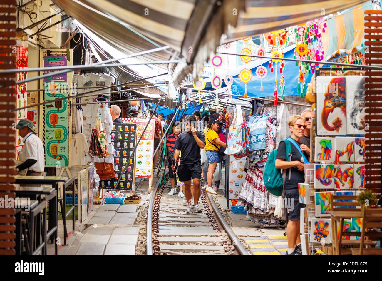 Samut Songkhram, June 14, 2025. Tourists walk along the railway track ...