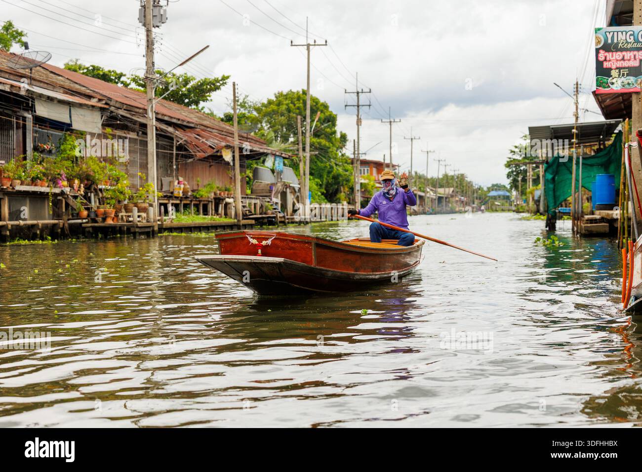 Damnoen Saduak, June 14, 2025. Boat operator poses for the camera along ...