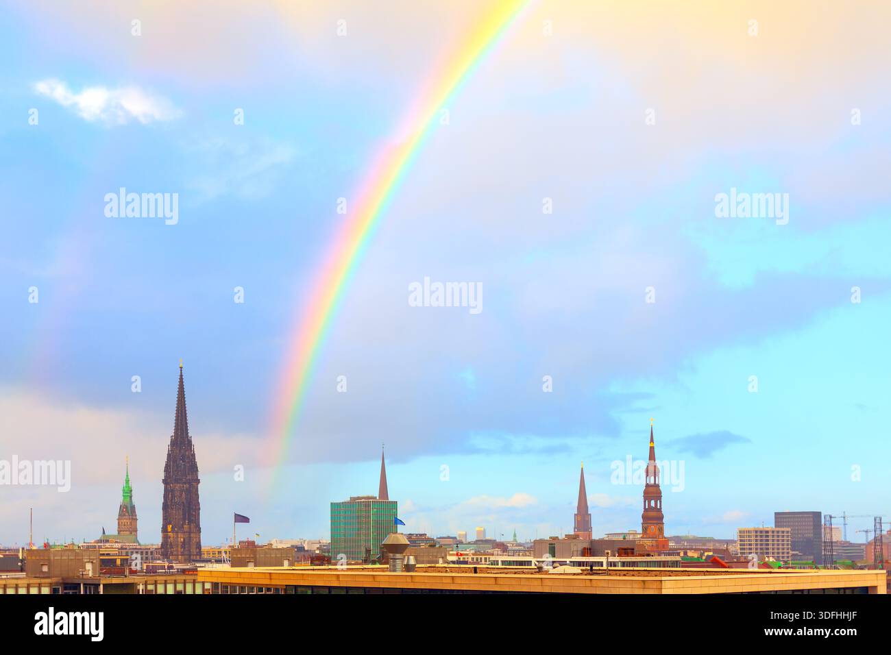 Rainbow arching over Hamburg city skyline in Germany. Several historic ...