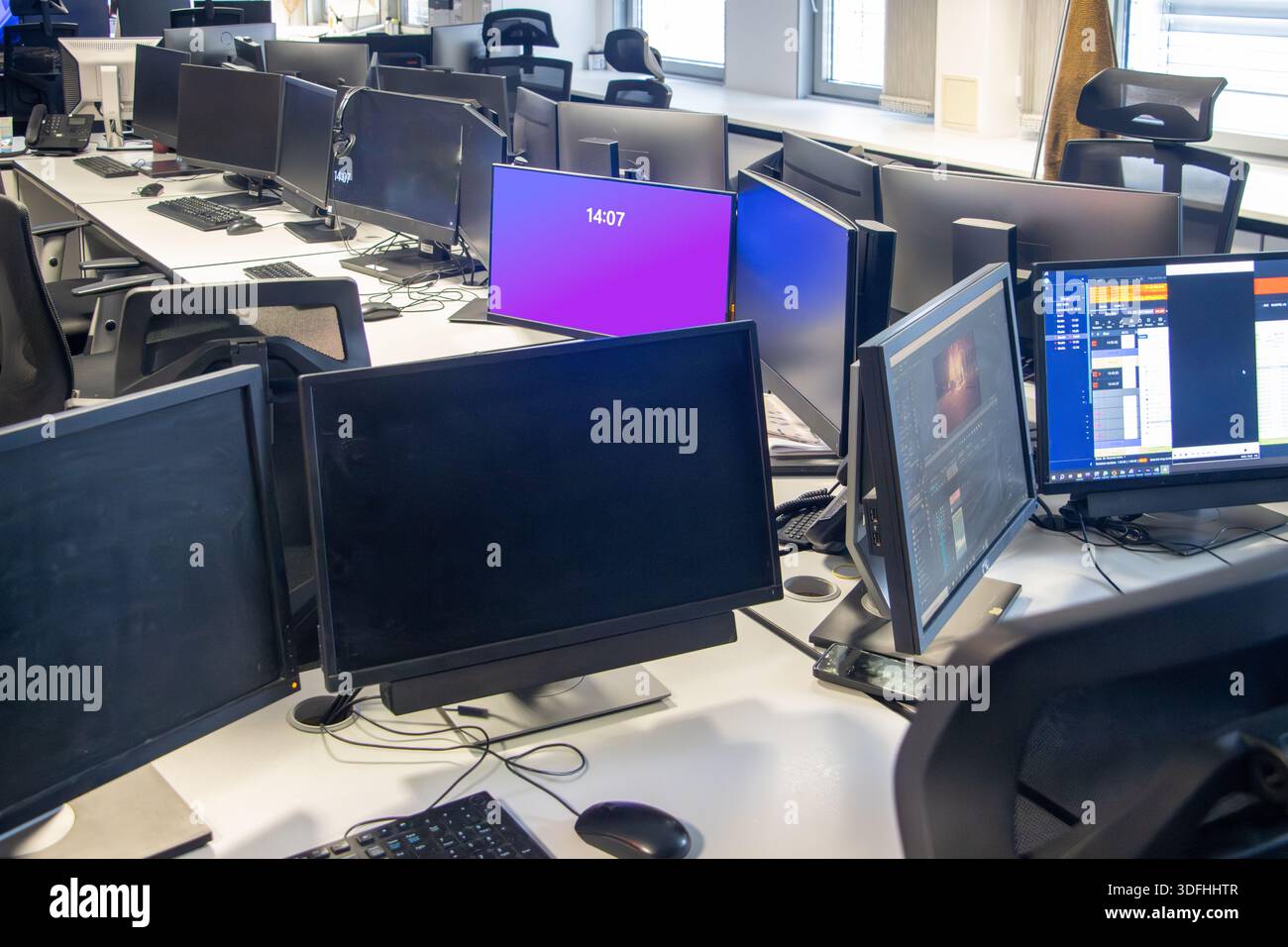 A modern open-plan office featuring rows of desks, ergonomic chairs and ...