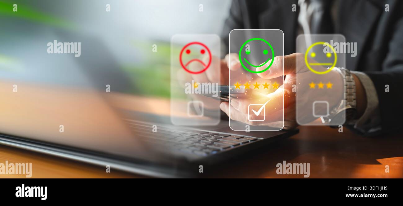 Businessman using smartphone over laptop with smiley and star rating ...