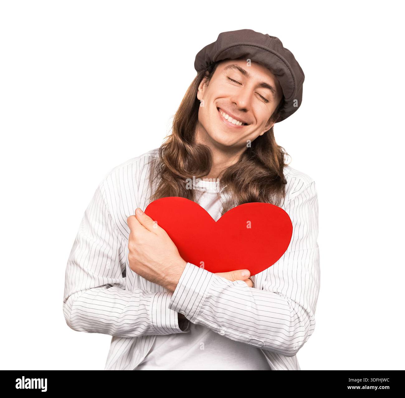 Happy man with long hair and cap hugging a red heart with eyes closed ...