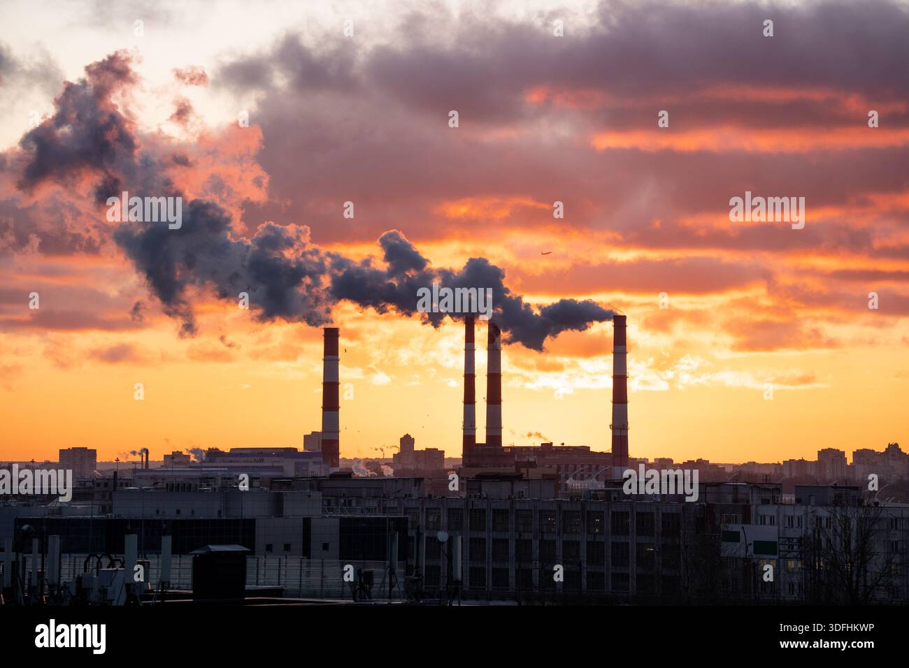 Smoke from factory pipe of heat station in city in winter. Fuel oil or ...