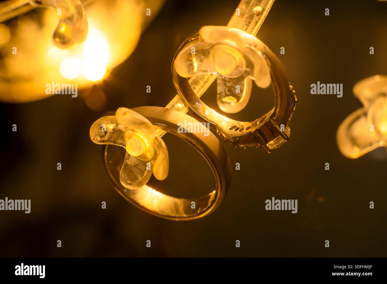 Wedding Rings Hanging on Warm Fairy Lights Stock Photo - Alamy