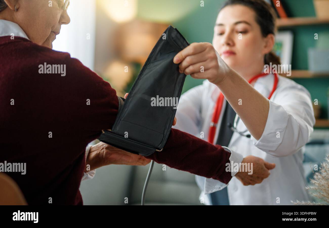 Doctor is measuring blood pressure to a senior woman Stock Photo - Alamy