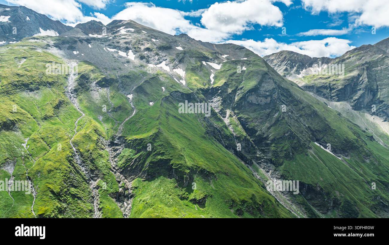 Majestic Mountain Range Scenery with Green Slopes and Patches of Snow ...