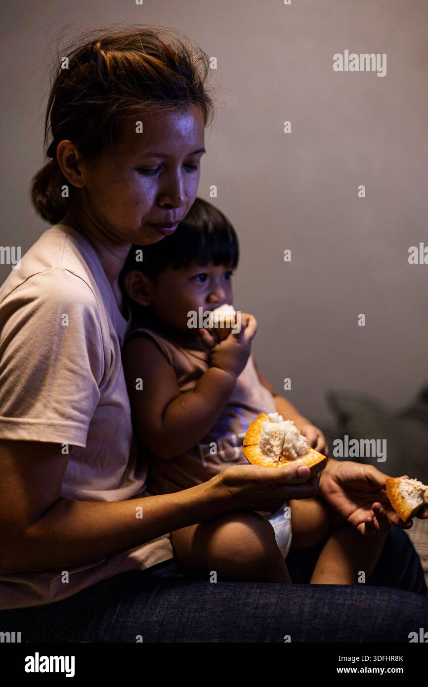Mom And Toddler Are Eating Santol, A warm ad photo of mom and toddler ...