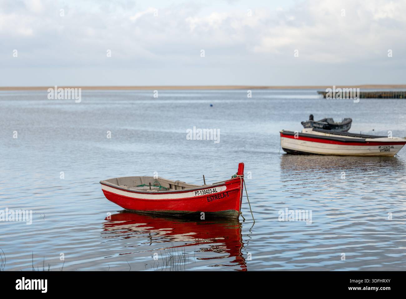Sesimbra Portugal December 25 2025. A red wooden fishing boat reflects ...