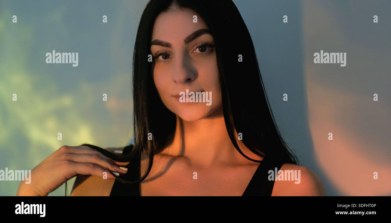 Shiny look. Face flare. Pretty woman in dark touching body skin ...