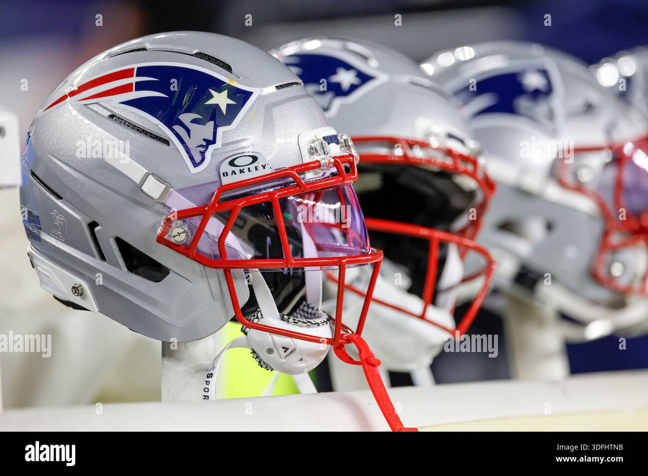 A collection of the New England Patriots helmets rest on the bench at ...