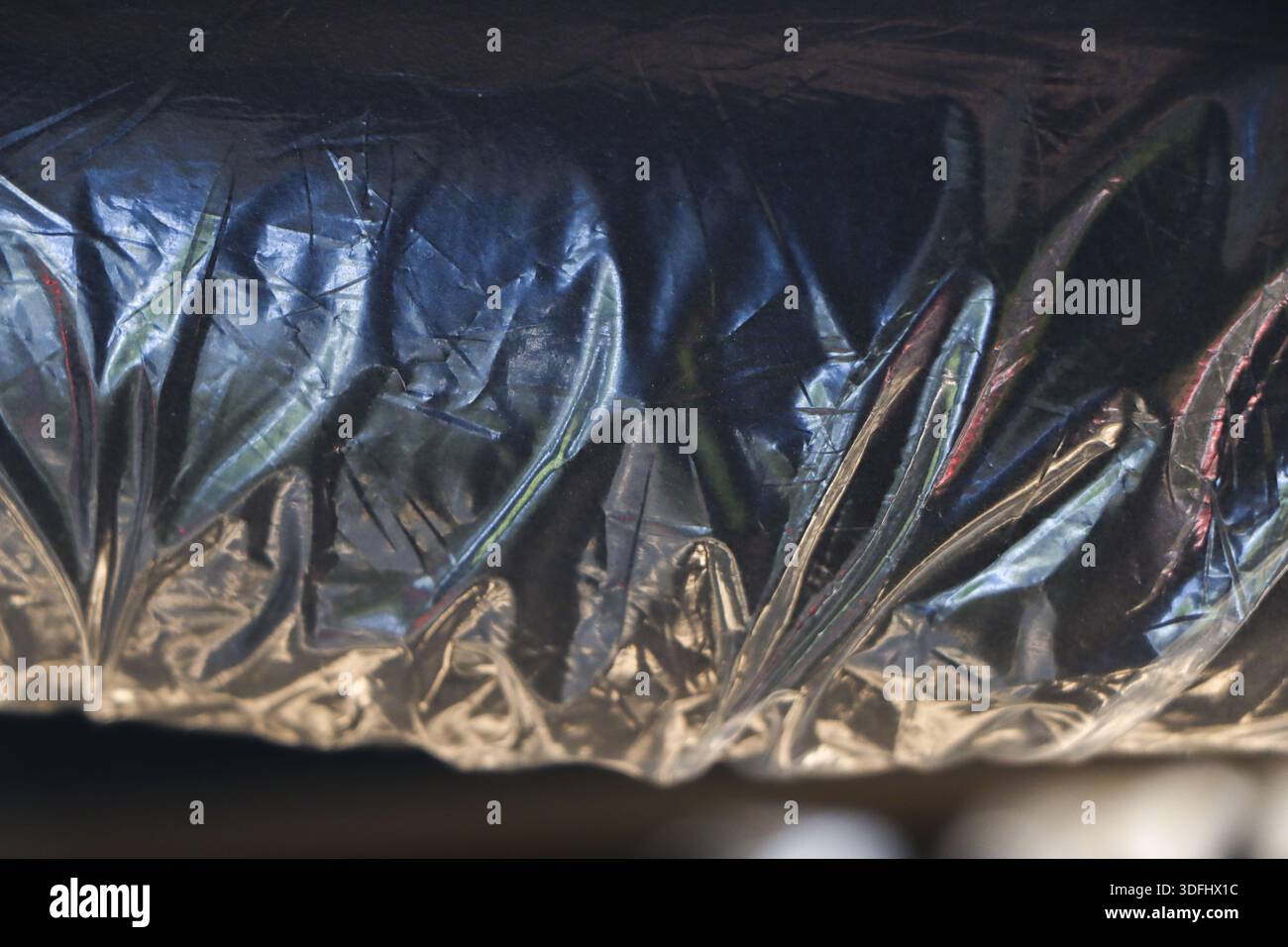 Silver aluminum foil insulation pipe wrapping duct work in dark attic ...