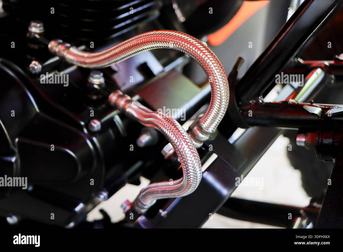 Close up shot detailed metallic braided oil cooler hose line connected ...