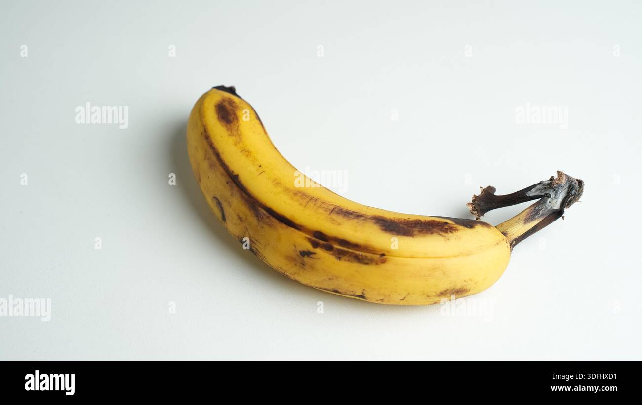 The bananas is medium ripe with brown spots all over the yellow skin ...