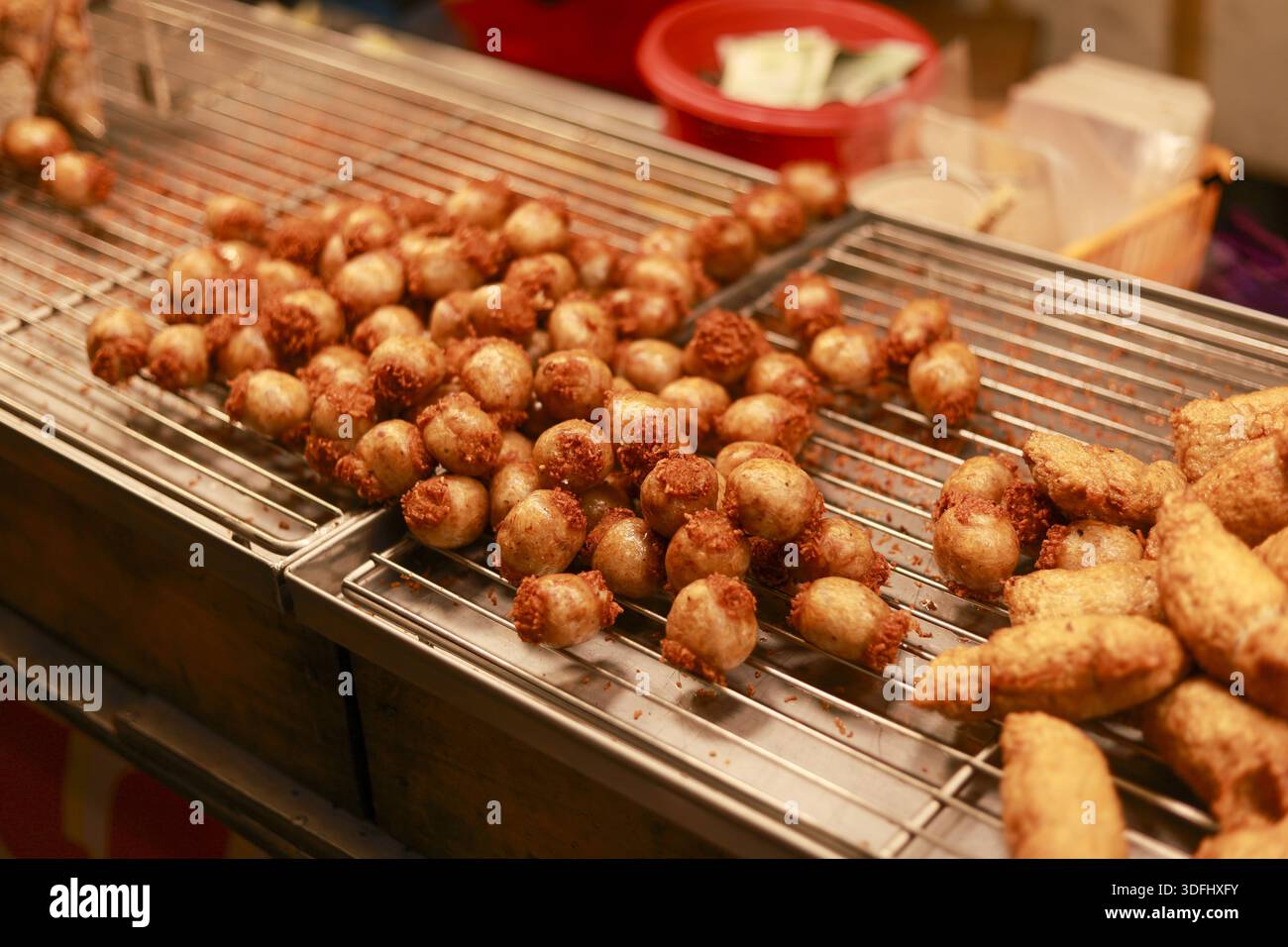 Delicious grilled Thai fermented pork sausage balls cooking on metal ...