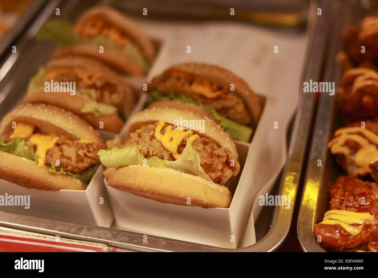 Crispy fried chicken burger sandwich on metal tray with melted cheese ...