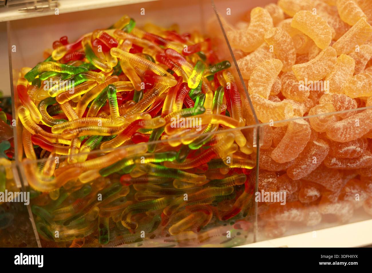 Cheerful colorful gummy candy in clear plastic bin sweet sugary treat ...