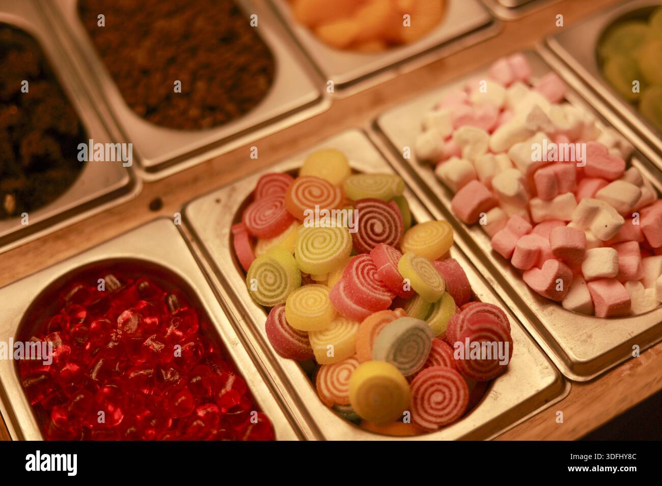 Assorted colorful sweet candy topping in metal tray for frozen yogurt ...