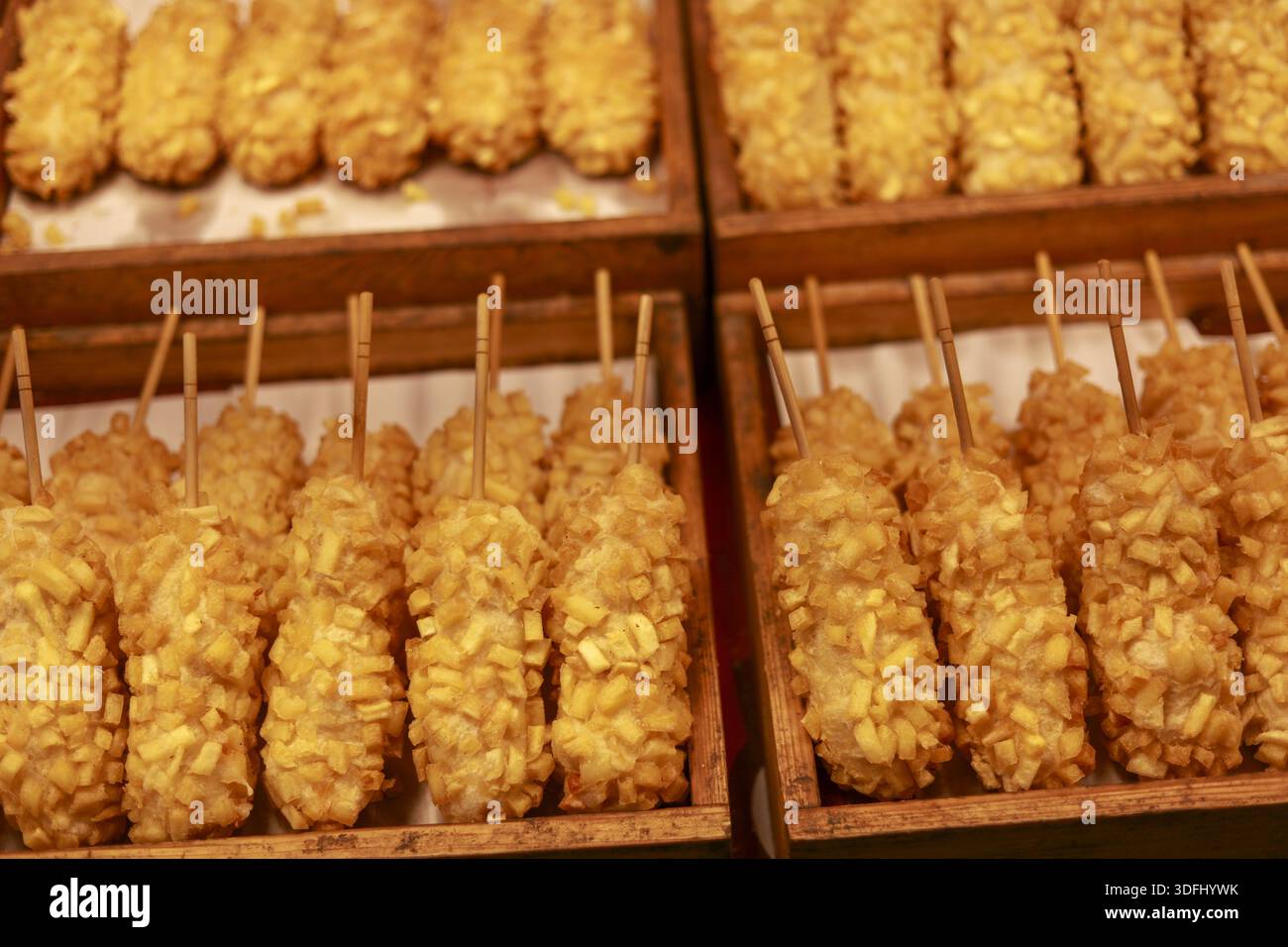 Crispy golden fried corn dog battered sausage on wooden stick arranged ...