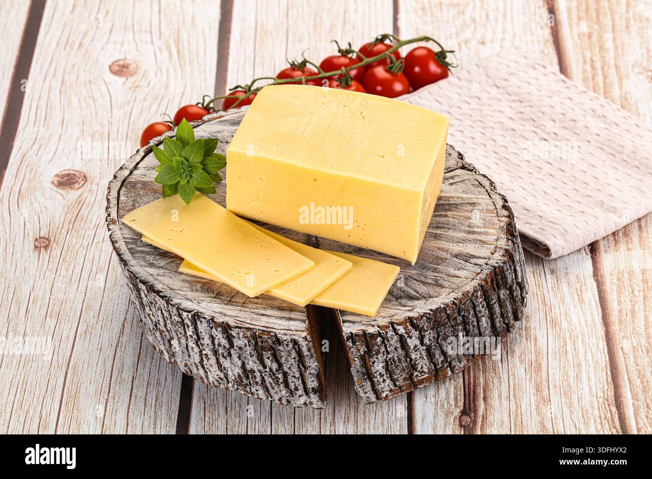 Yellow cheese piece with slices served basil Stock Photo - Alamy