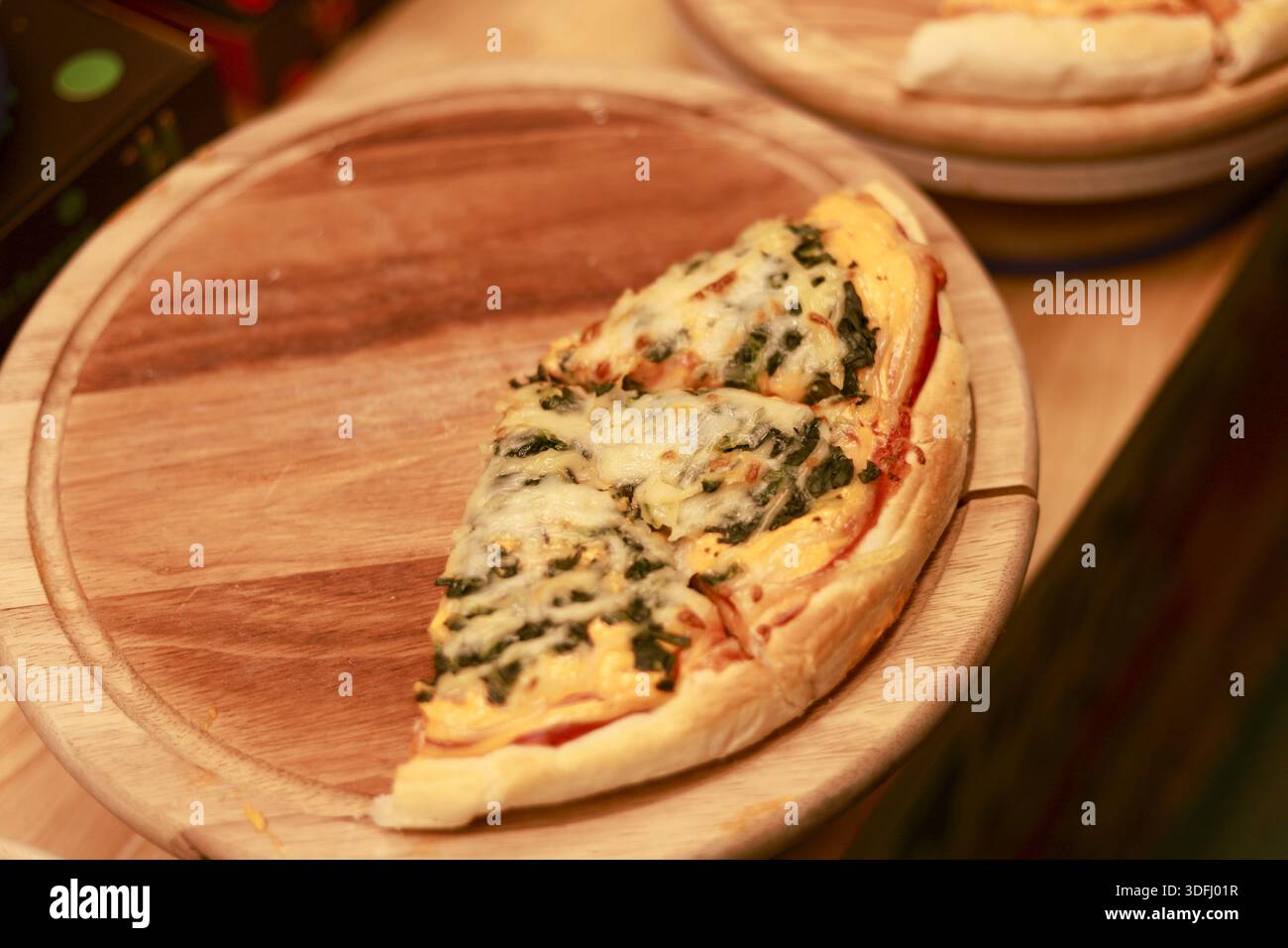 Delicious homemade cheesy pizza slice rustic round wooden board with ...