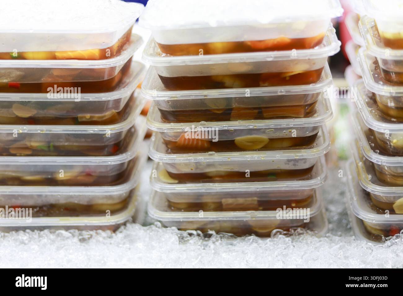 Stack of plastic food container with fresh brown curry or soup frozen ...