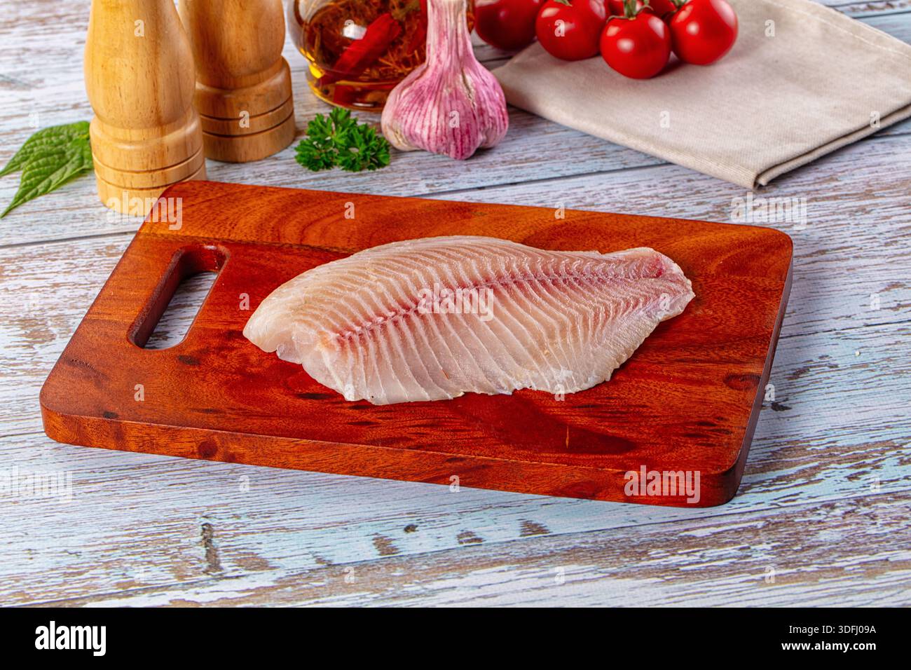 Raw tilapia fish fillet over board for cooking Stock Photo - Alamy