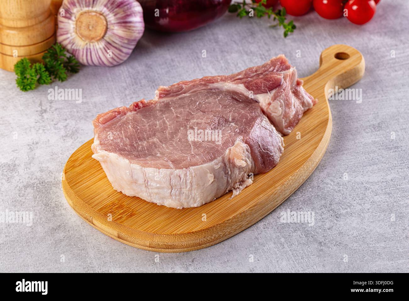 Raw pork steak with bone over board Stock Photo - Alamy