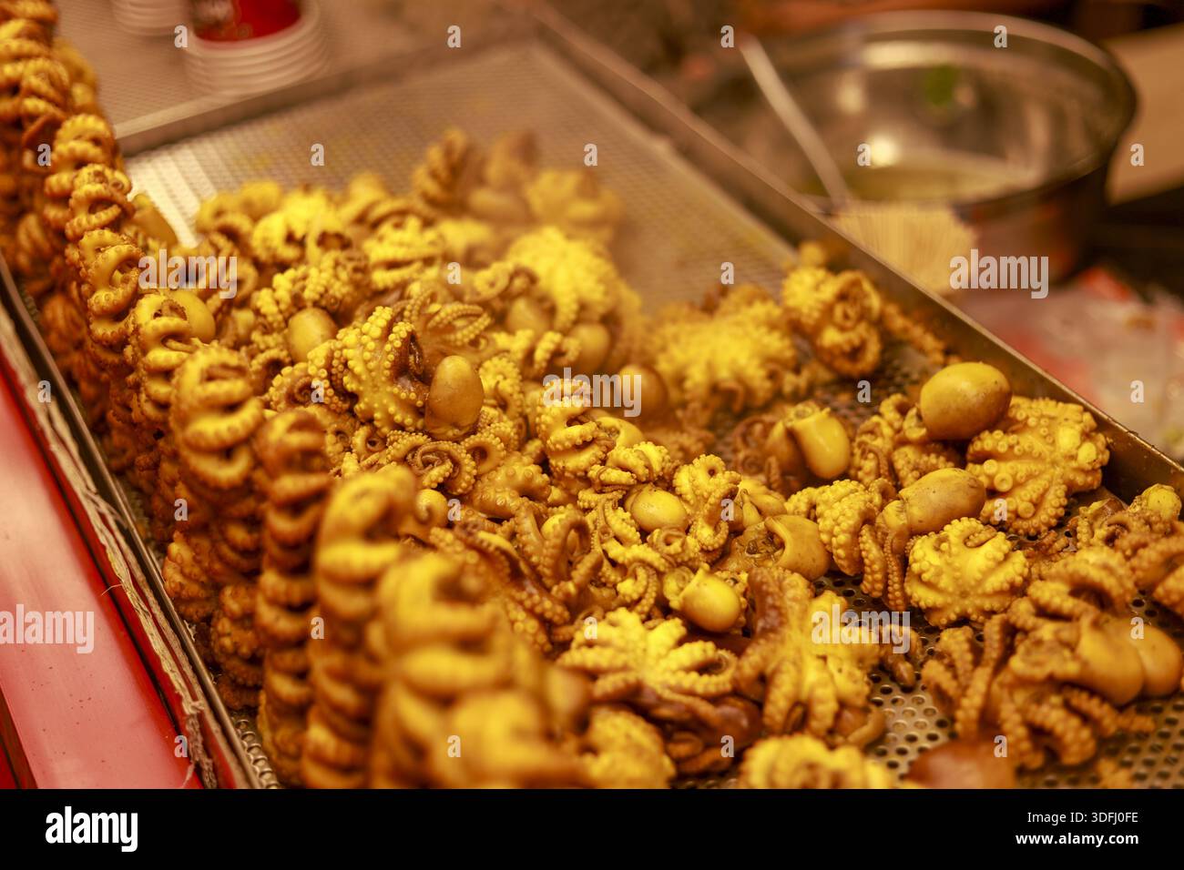 Tasty grilled octopus and squid skewers on metal tray offering ...