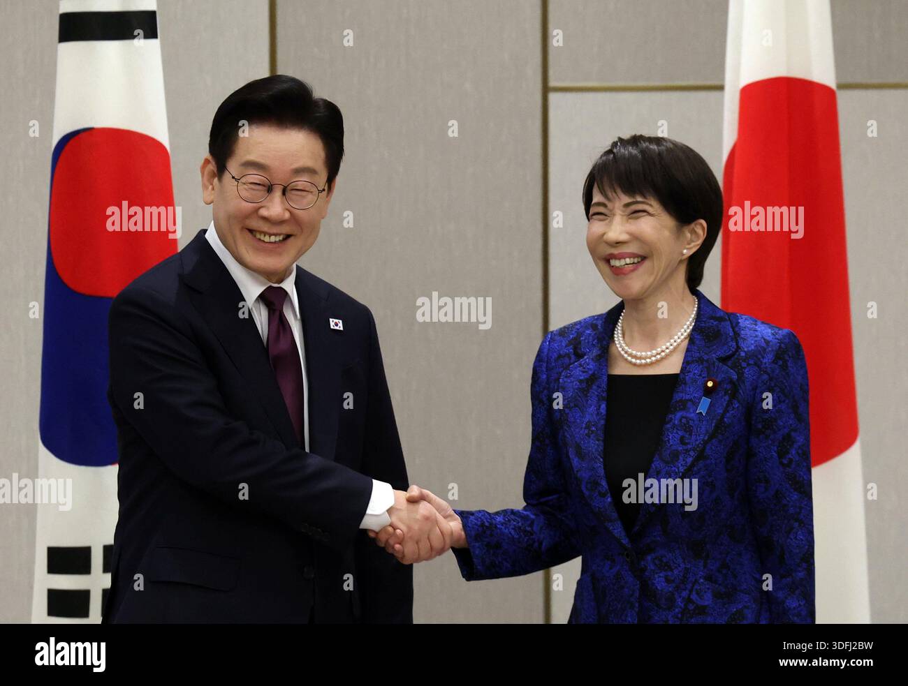 Japan's Prime Minister Sanae Takaichi, right, shakes hands with South ...