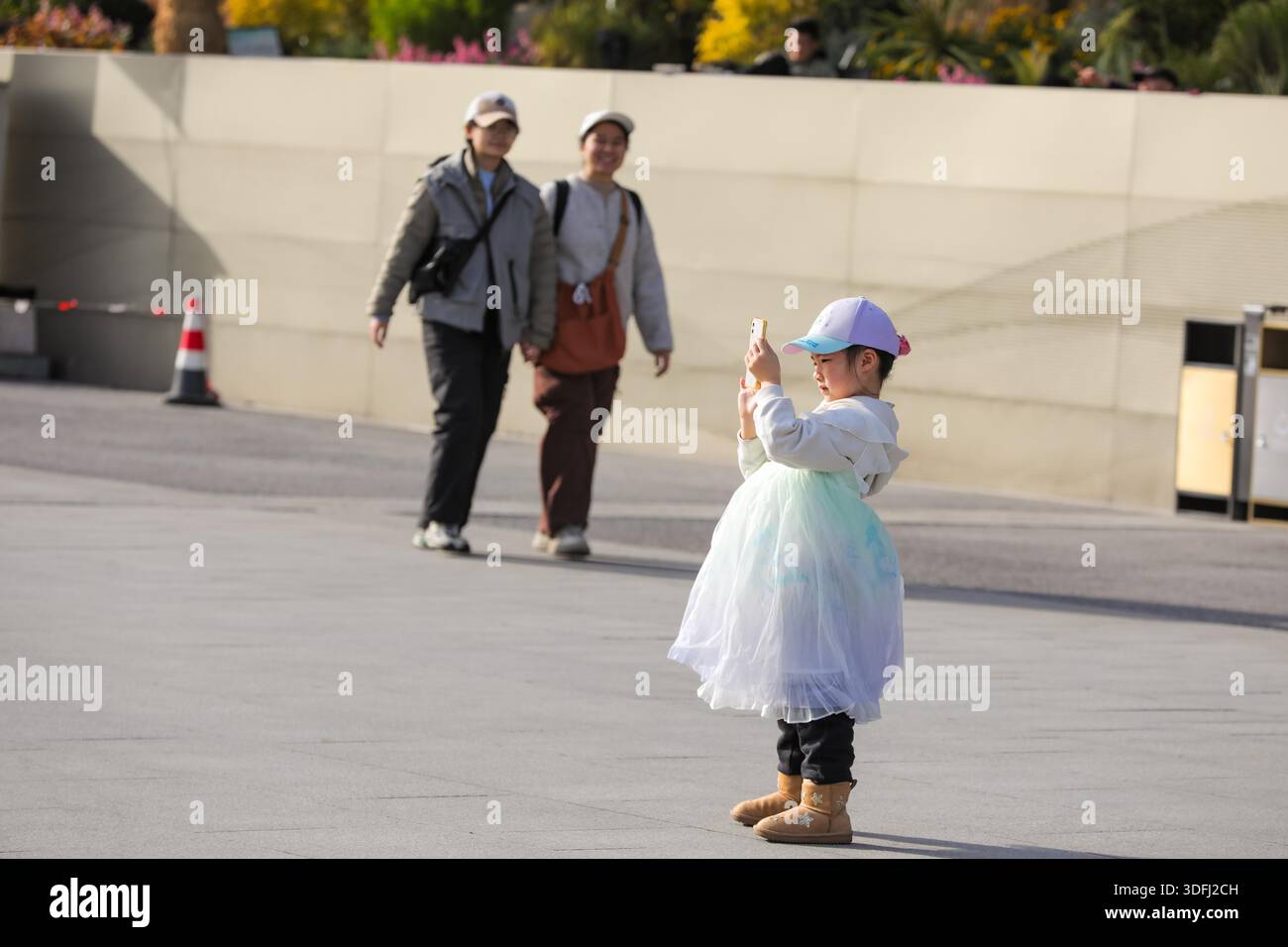 Tourists stroll along the riverside walkway in Hongkou District ...