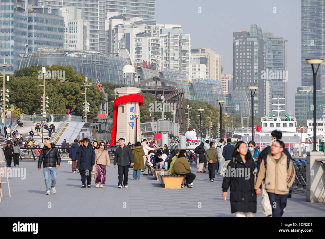 Tourists stroll along the riverside walkway in Hongkou District ...