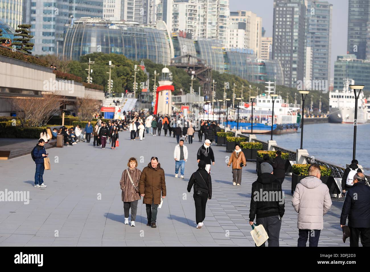 Tourists stroll along the riverside walkway in Hongkou District ...