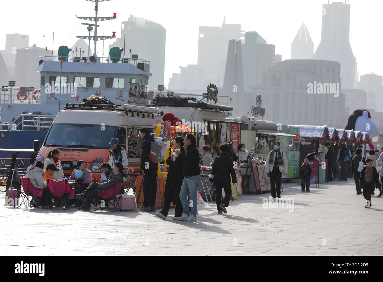 Tourists stroll along the riverside walkway in Hongkou District ...