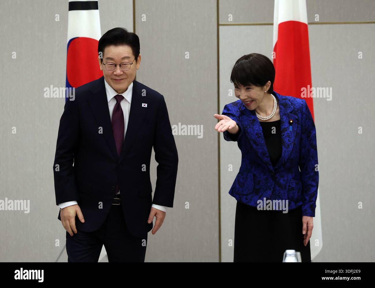 South Kore's President Lee Jae Myung, left, is escorted by Japan's ...