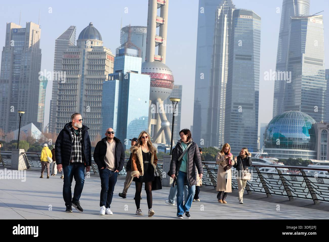 Tourists stroll along the riverside walkway in Hongkou District ...