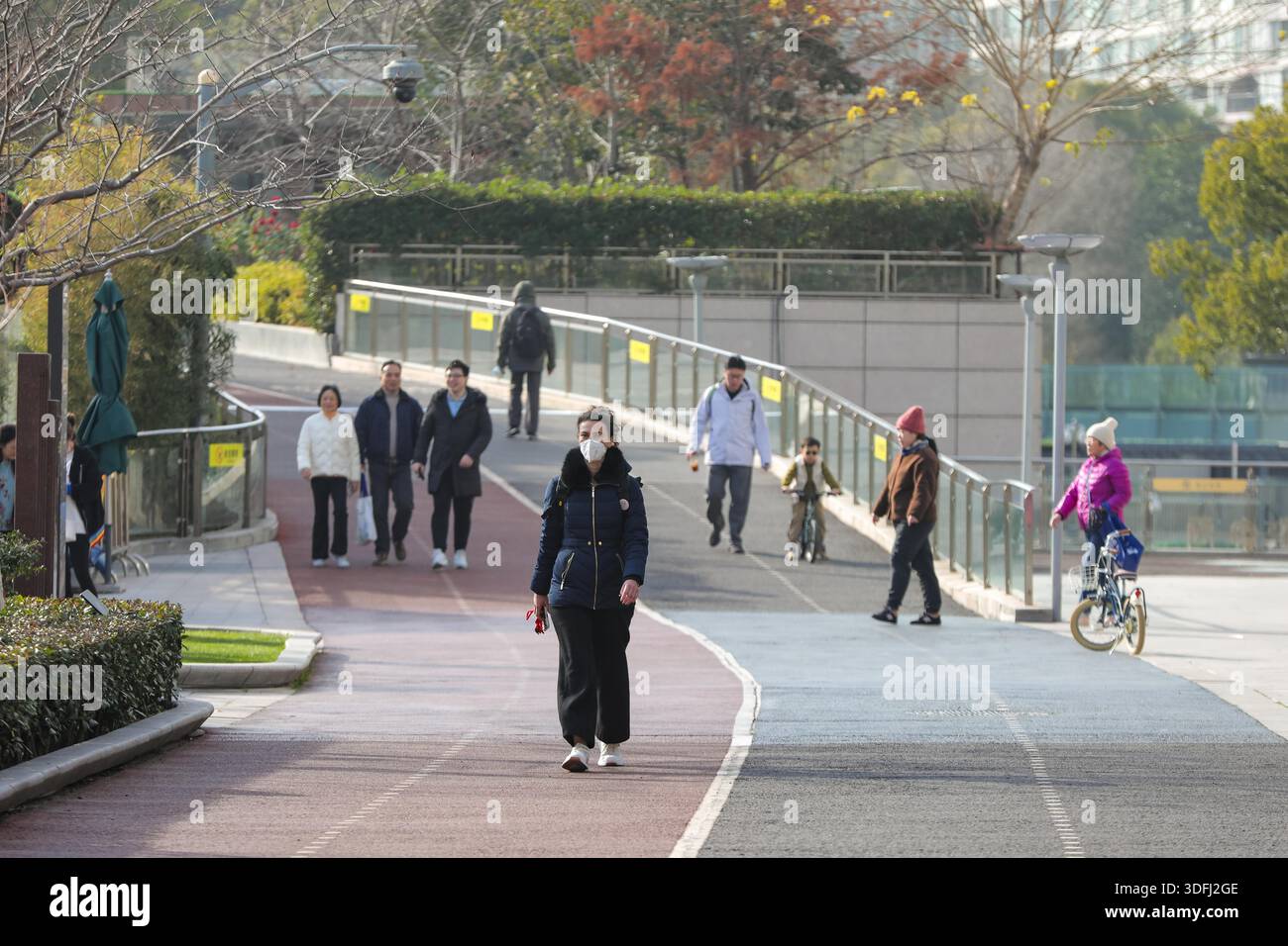 Tourists stroll along the riverside walkway in Hongkou District ...