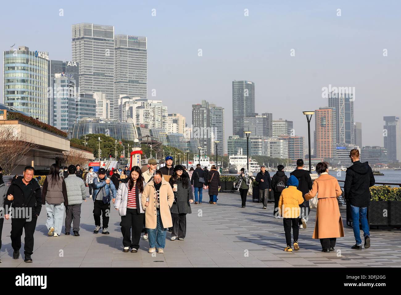 Tourists stroll along the riverside walkway in Hongkou District ...
