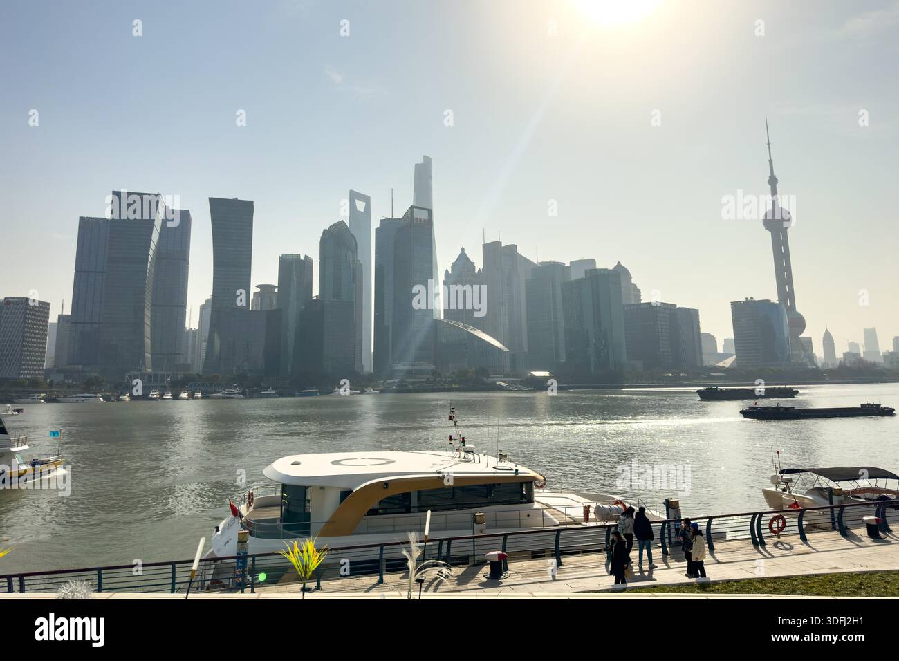 Tourists stroll along the riverside walkway in Hongkou District ...