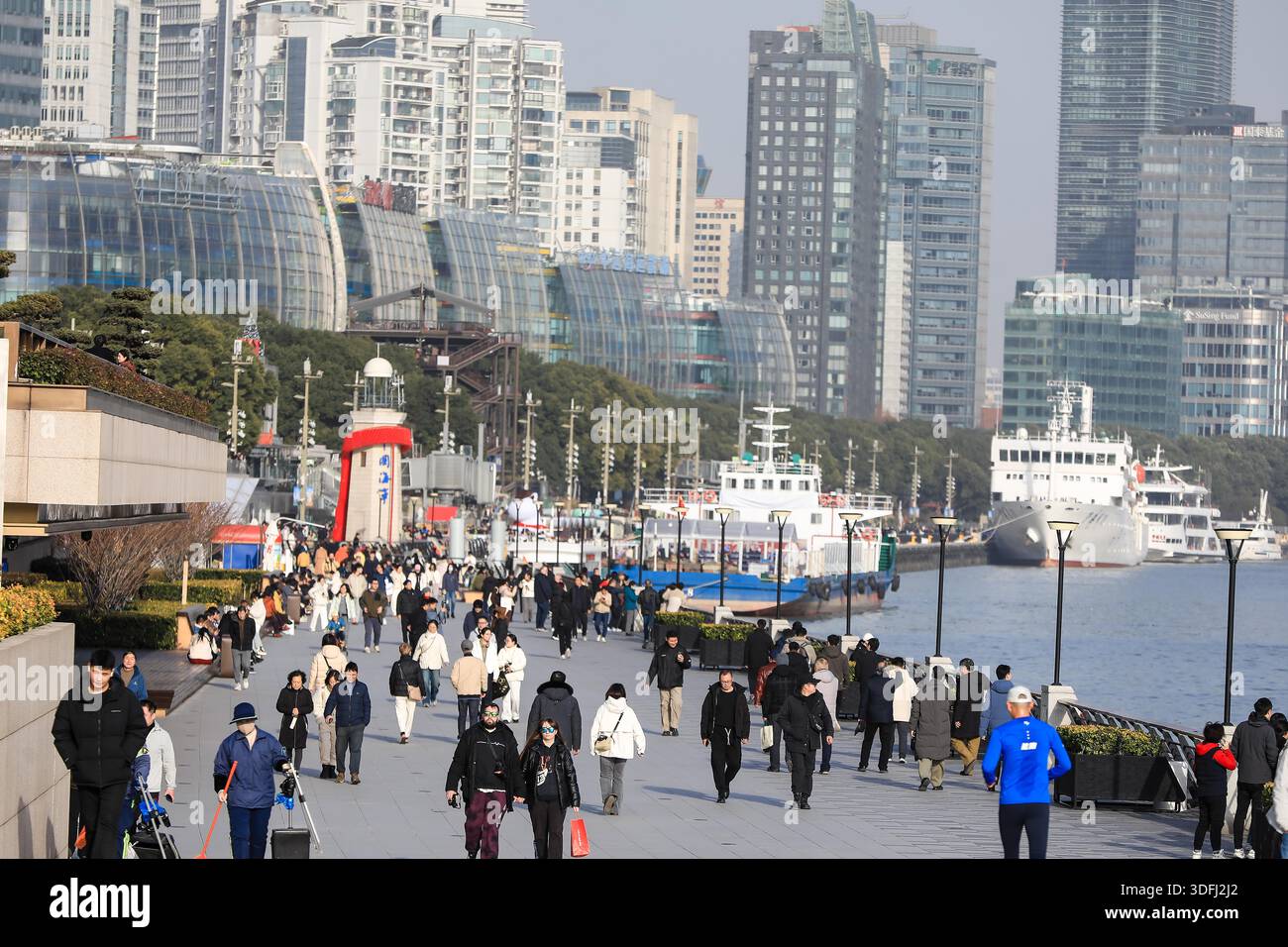 Tourists stroll along the riverside walkway in Hongkou District ...