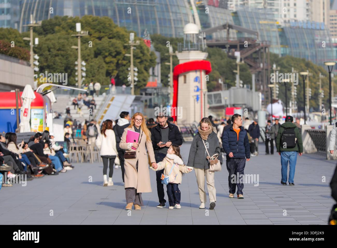 Tourists stroll along the riverside walkway in Hongkou District ...