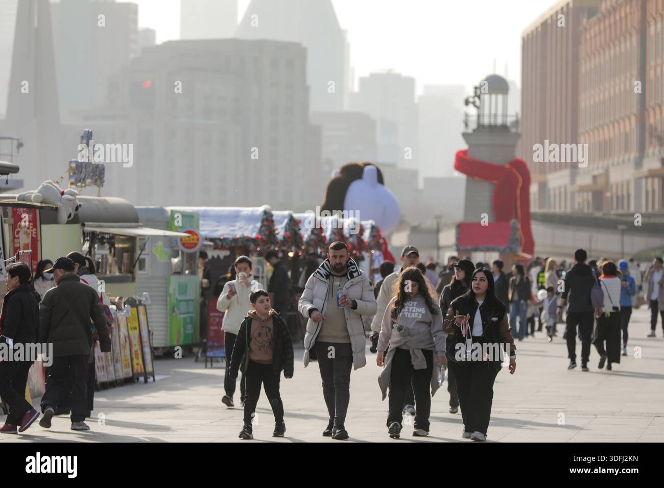 Tourists stroll along the riverside walkway in Hongkou District ...