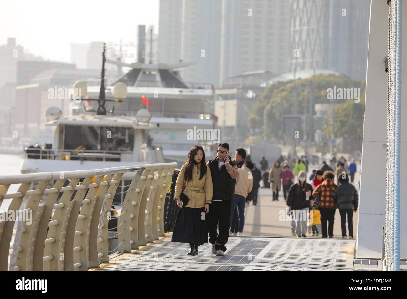 Tourists stroll along the riverside walkway in Hongkou District ...
